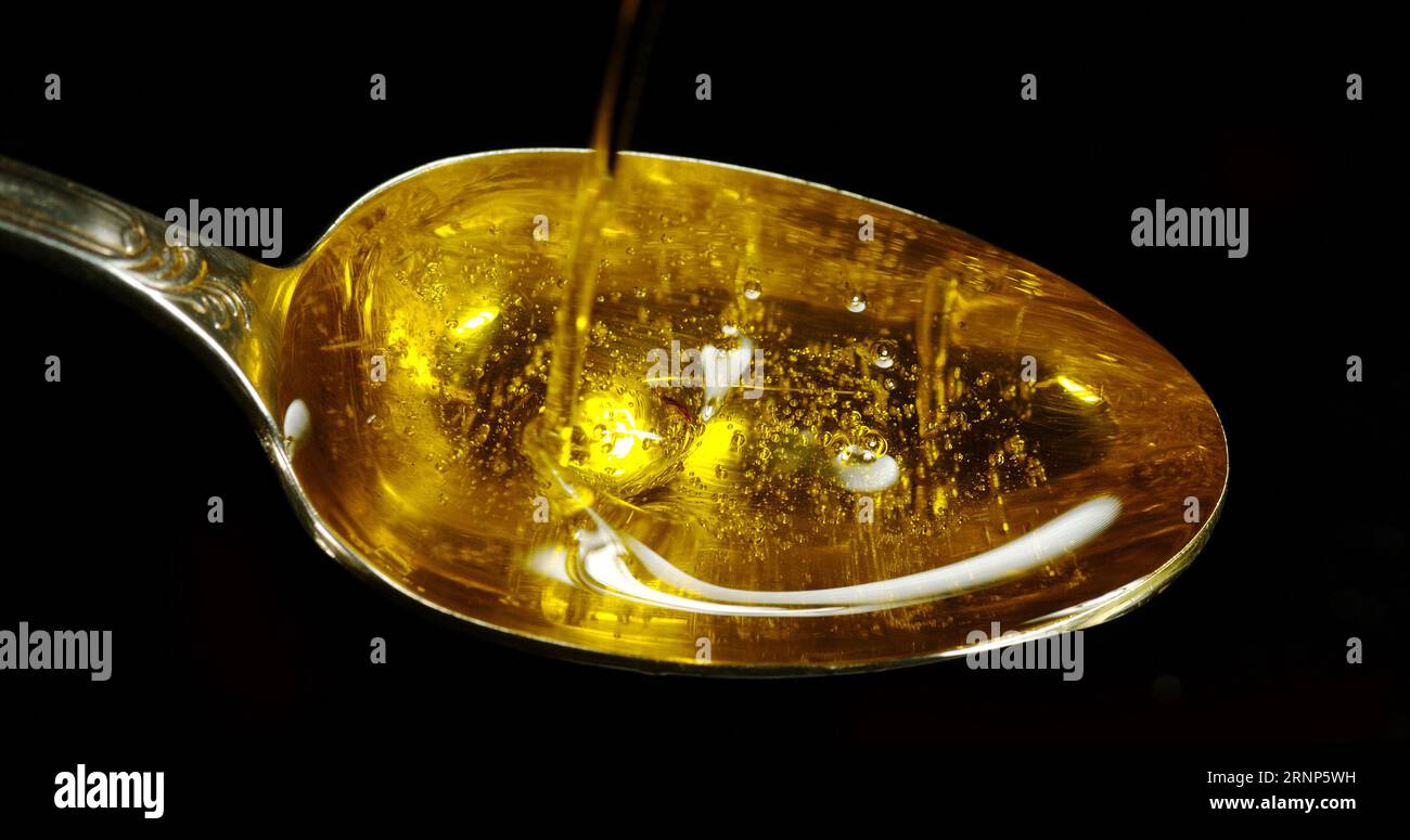 Olive Oil, Falling in a Spoon against Black Background Stock Photo - Alamy