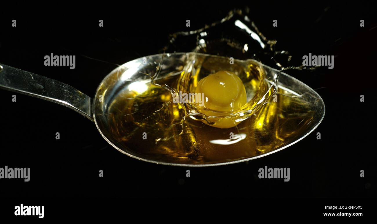 Green Olive, Olea europaea, Falling in a Spoon against Black Background ...