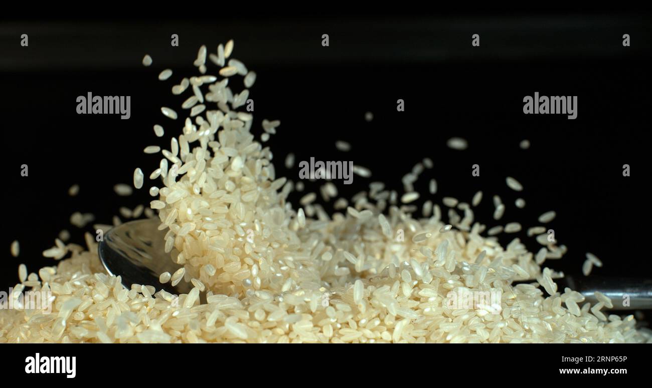 Rice falling against Black Background Stock Photo - Alamy