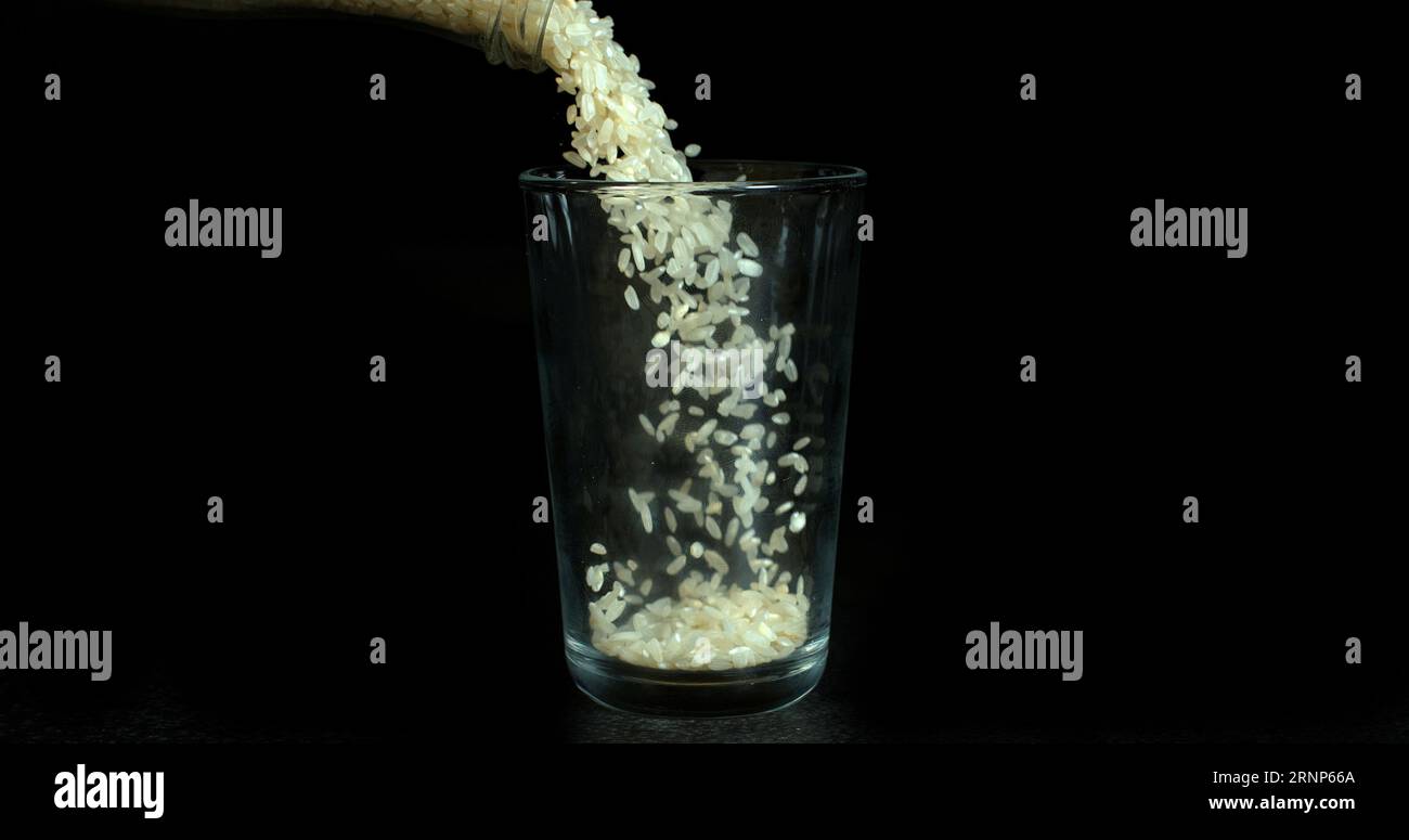 Rice falling against Black Background Stock Photo - Alamy
