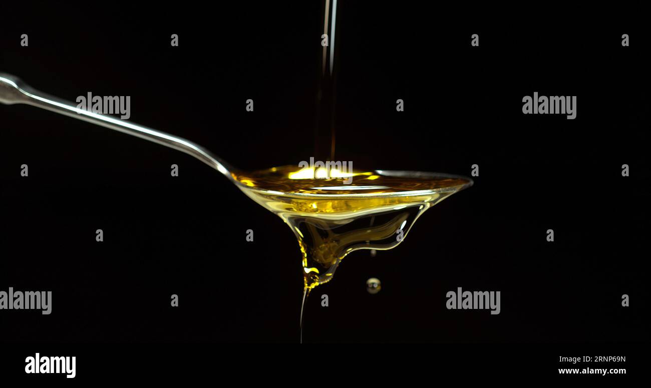 Olive Oil, Falling in a Spoon against Black Background Stock Photo - Alamy
