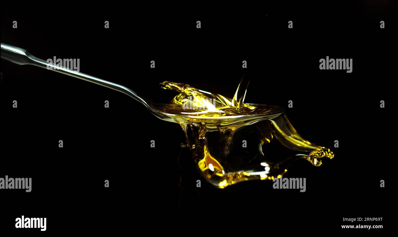 Olive Oil, Falling in a Spoon against Black Background Stock Photo - Alamy