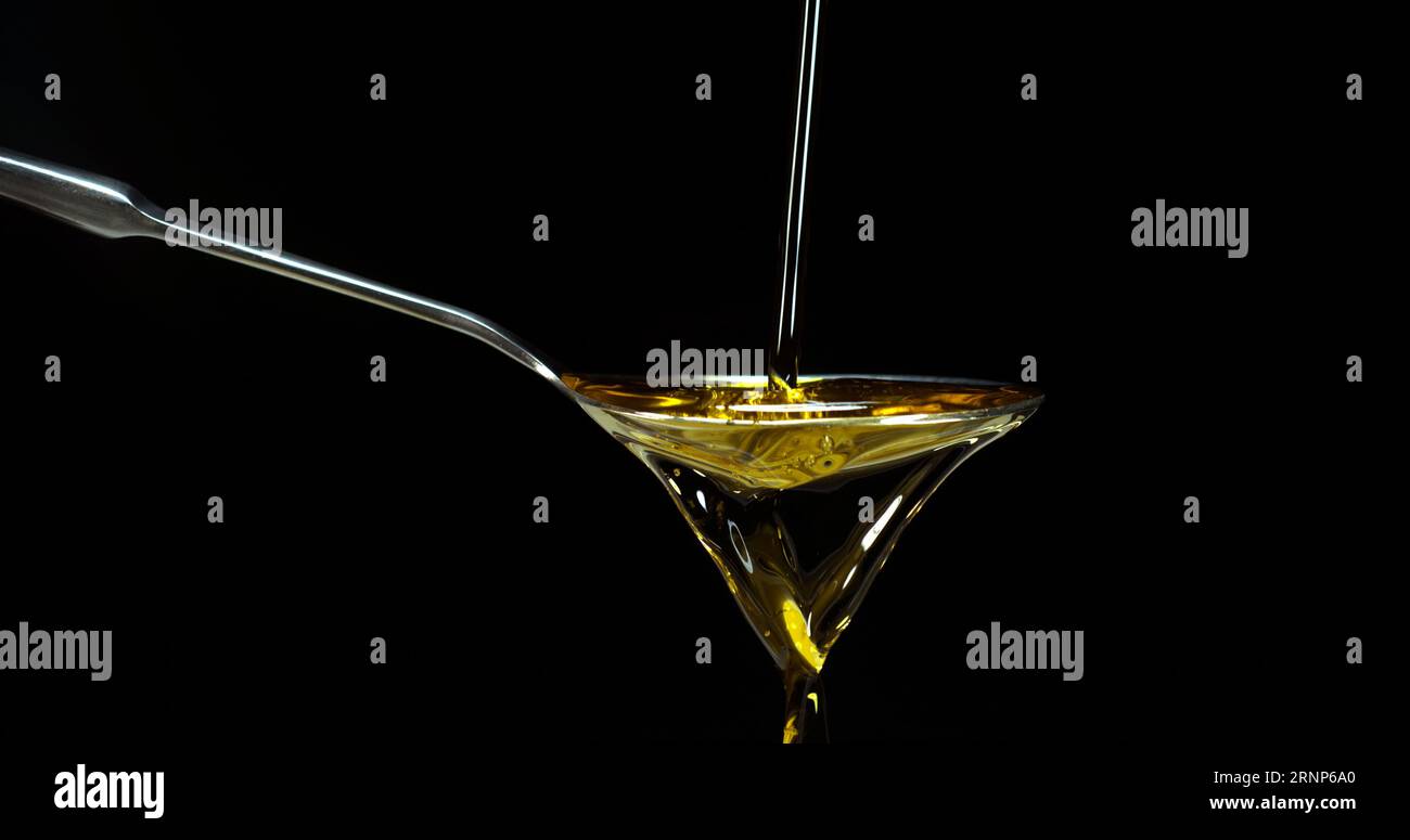 Olive Oil, Falling in a Spoon against Black Background Stock Photo - Alamy