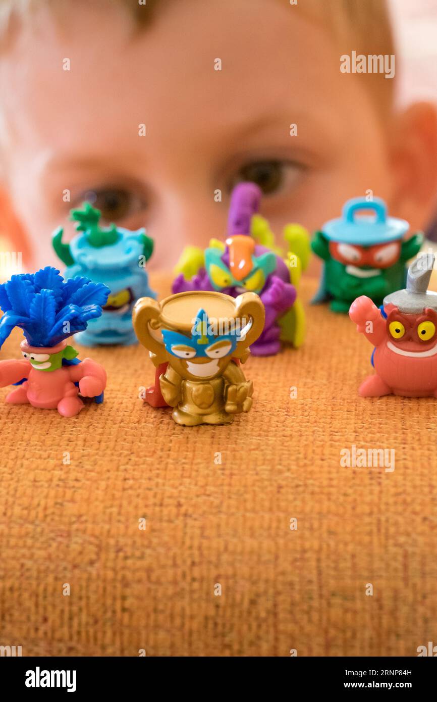 Cute little boy with blond hair staring and playing with his super ...
