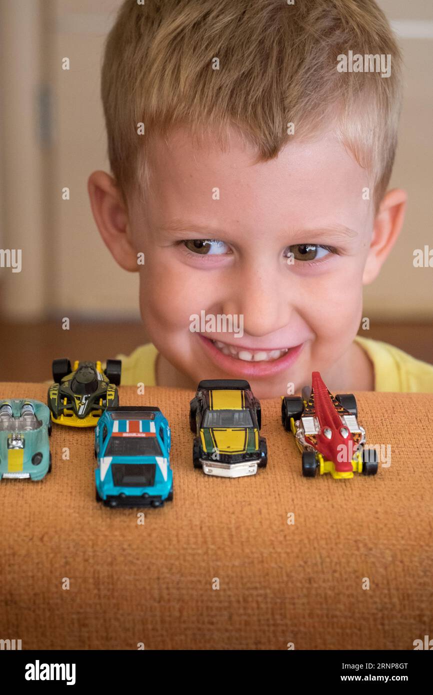 Cute little boy staring and playing with his hot wheel cars Stock Photo ...