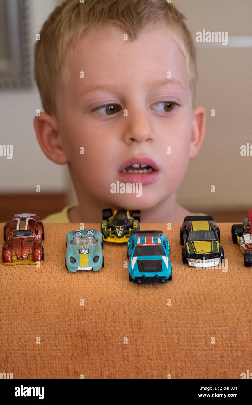 Cute little boy staring and playing with his hot wheel cars Stock Photo ...