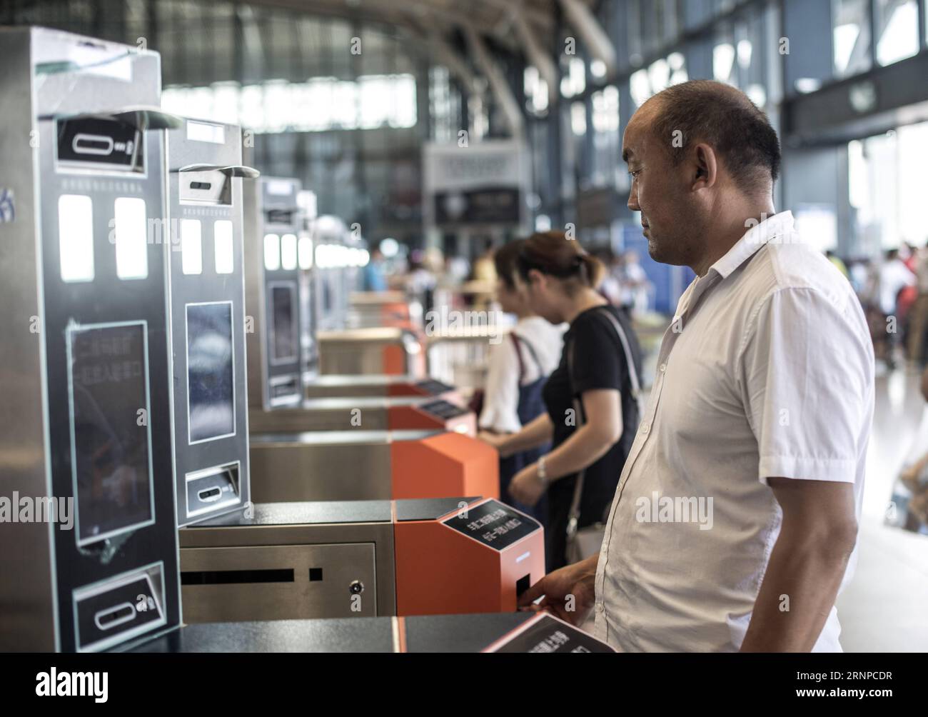 (170822) -- WUHAN, Aug. 22, 2017 -- A passenger uses his identification ...