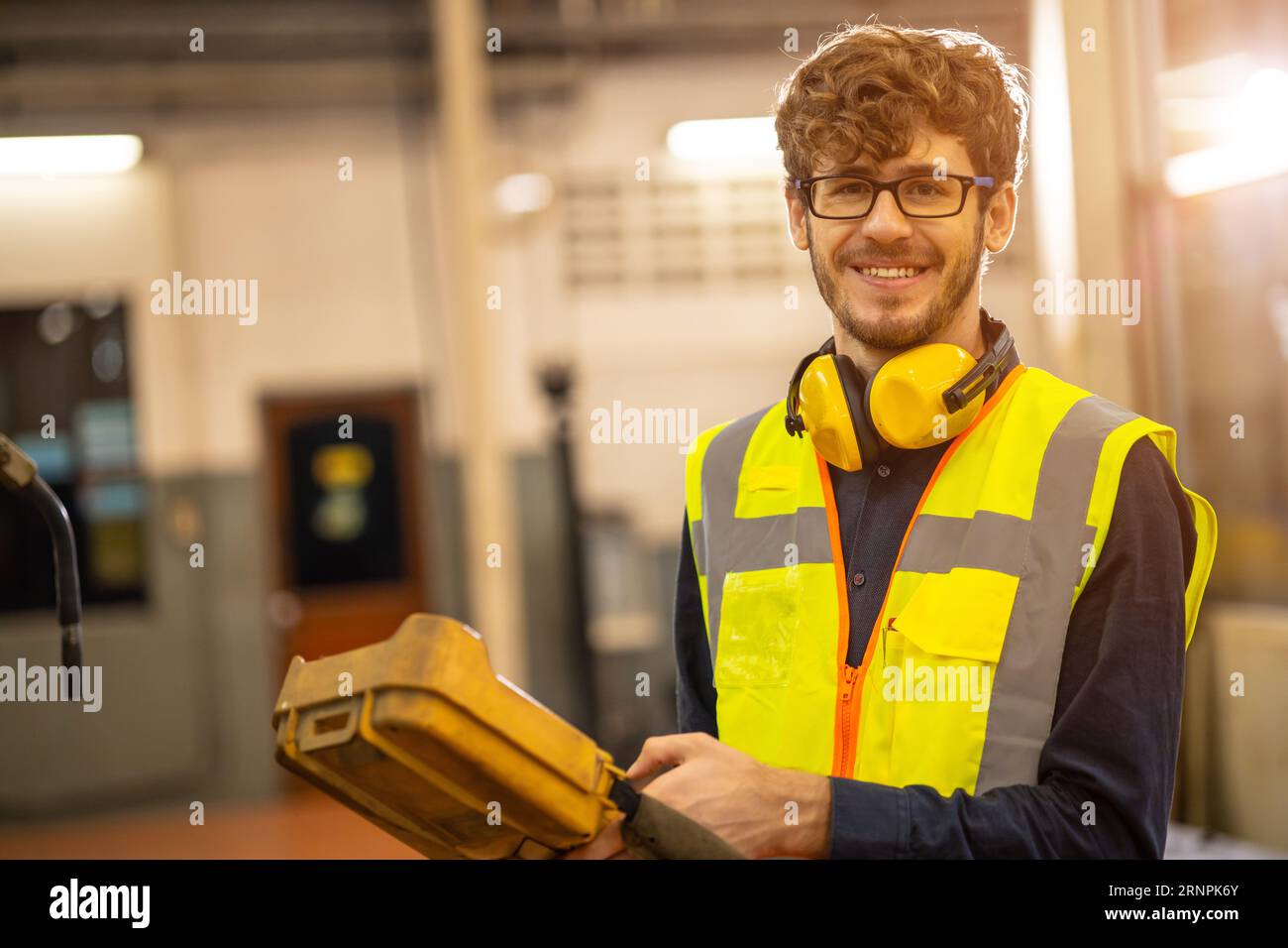 portrait happy young caucasian male worker robot arm machine operator ...