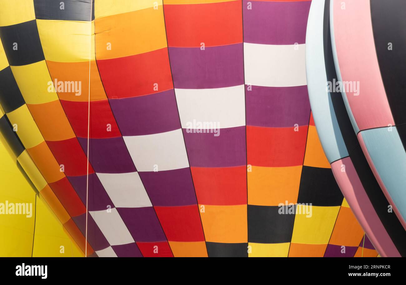 extreme closeup of hot air balloon with vibrant colors fully inflated ...