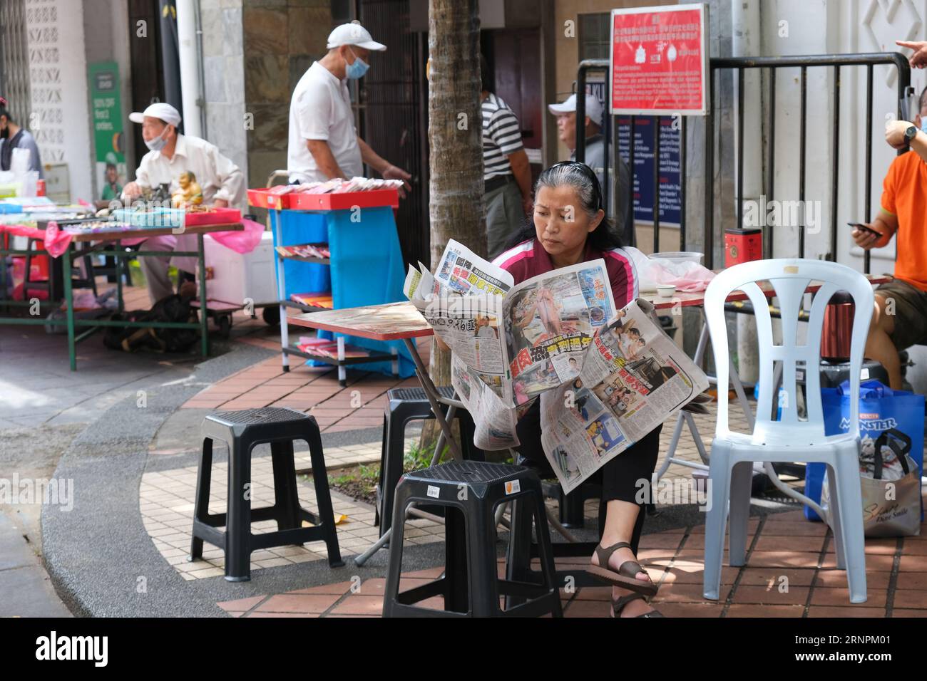 Chinese woman reads newspaper in Tan Hiok Nee heritage street, Johor ...