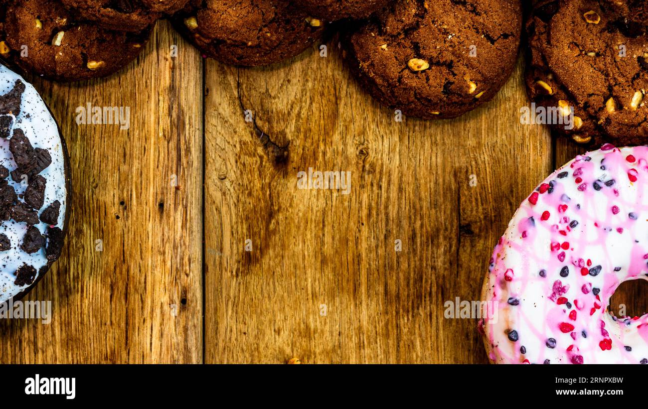 Frame made of chocolate chip cookies, biscuits and colorful donuts top ...
