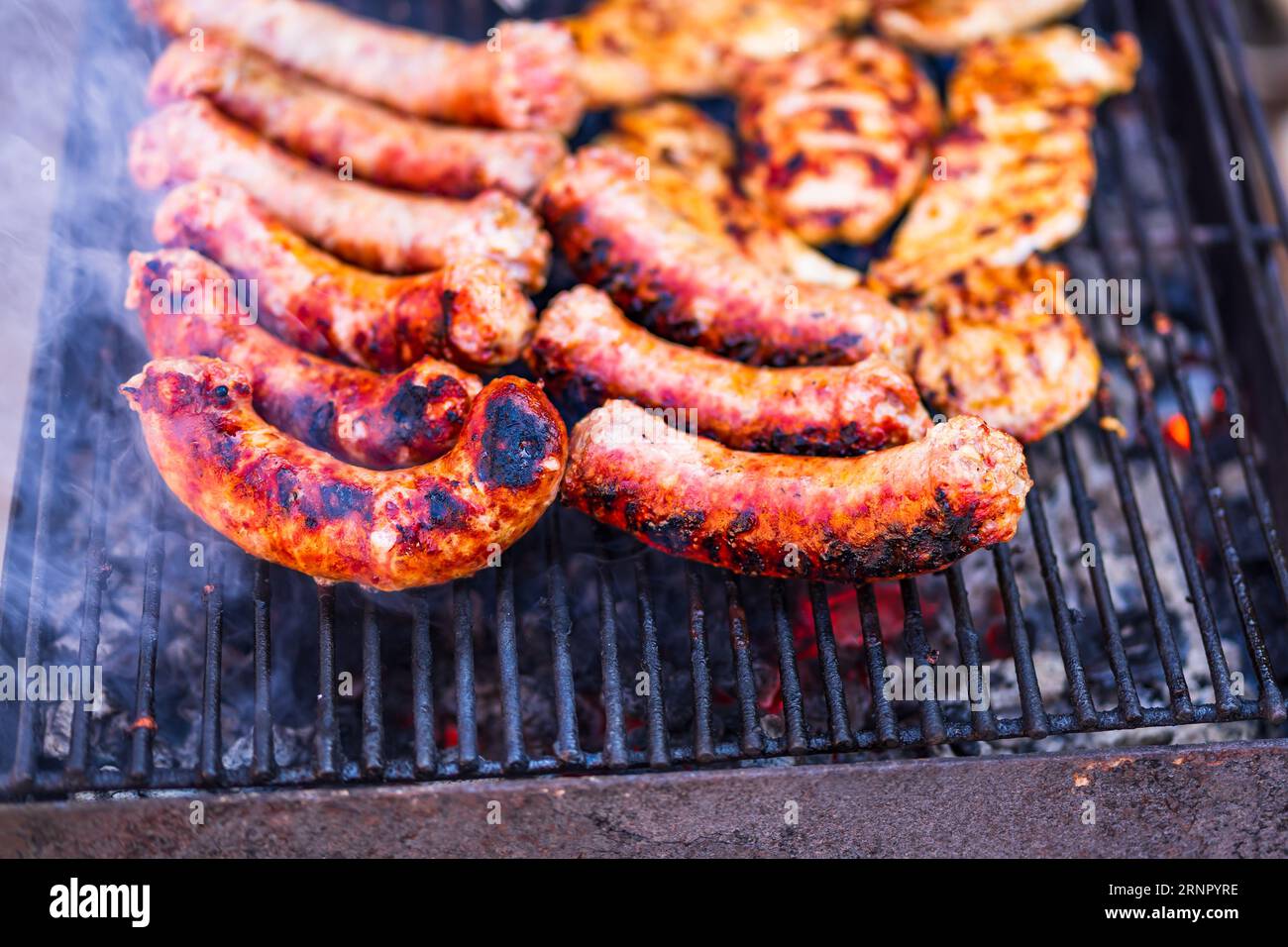 Preparing pork meat and sausages grilled on a charcoal barbeque. Top ...