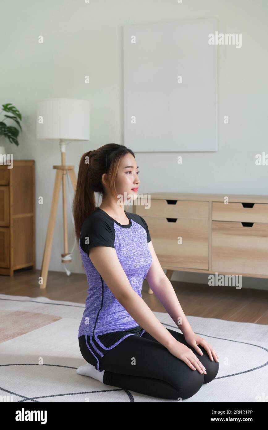 Young asian woman doing yoga exercise vajrasana diamond pose for ...