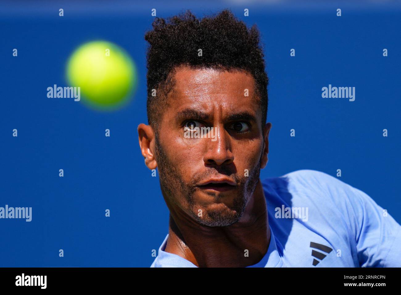 Michael Mmoh, of the United States, returns a shot to Jack Draper, of ...