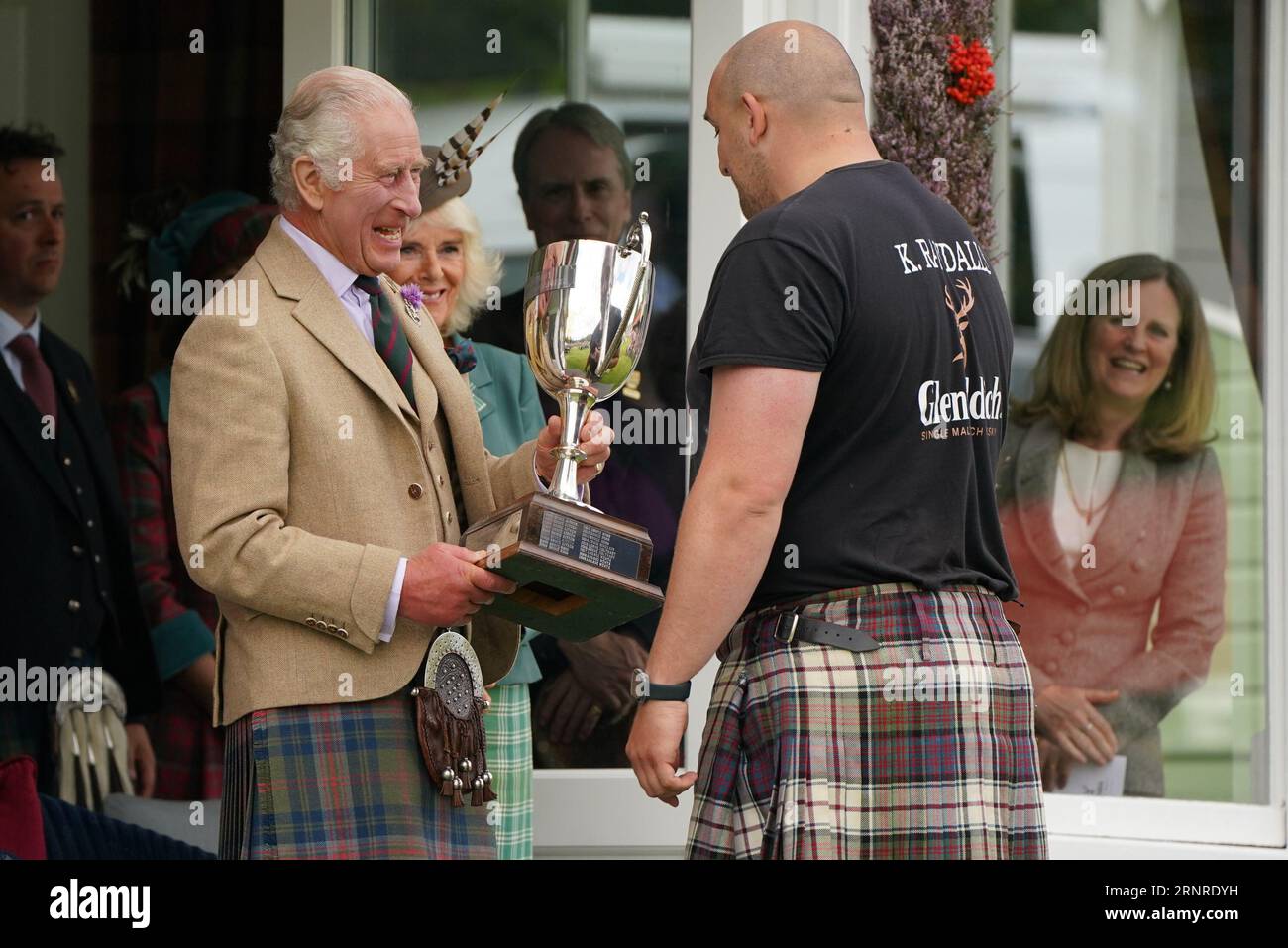 King Charles III hands out a trophy to one of the "heavies" (Scottish ...