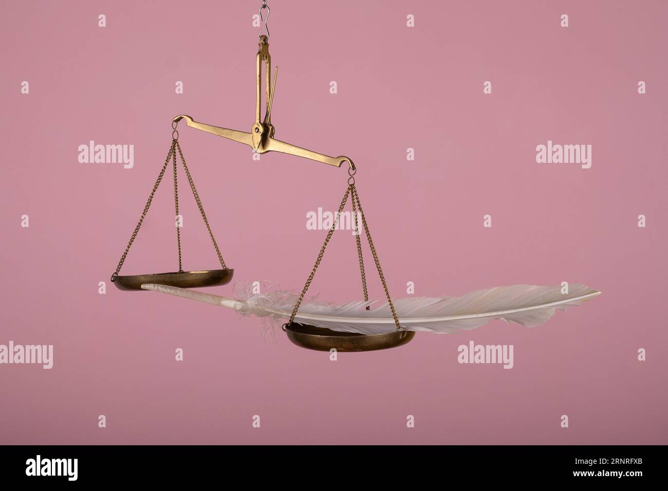 man hand holding a balance on pink background Stock Photo - Alamy