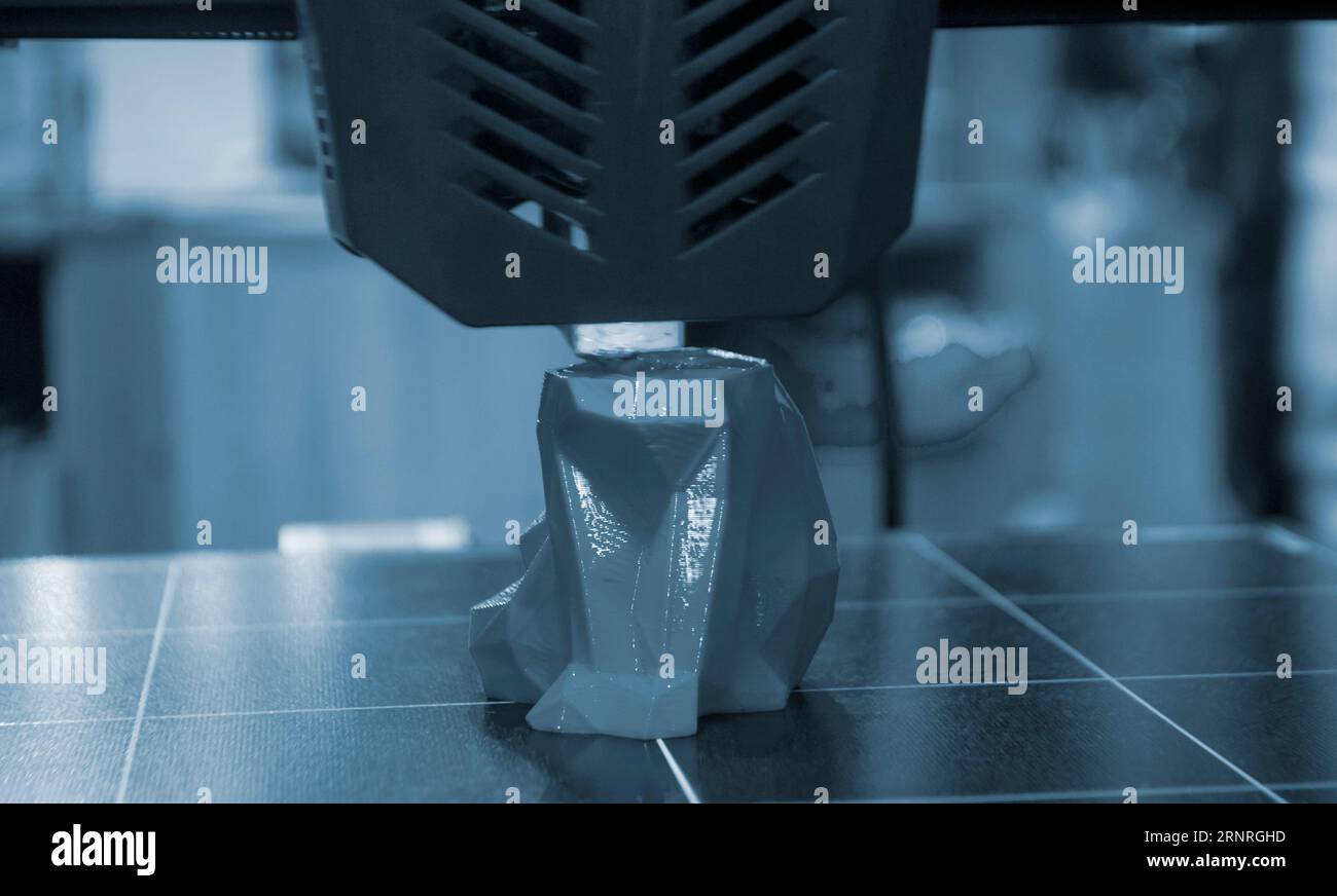 3D printer printing prototype of toy from molten plastic. Process of ...