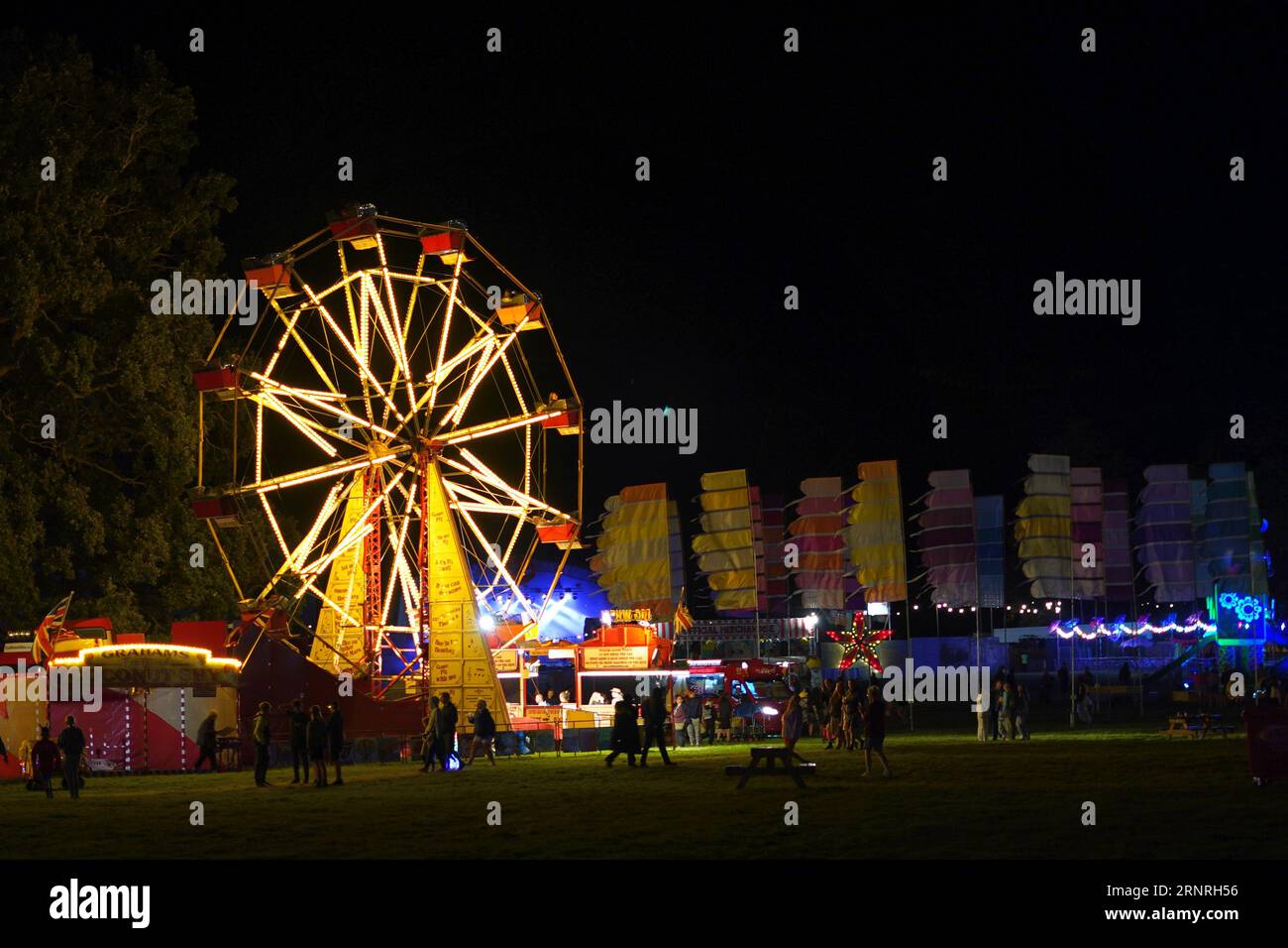 an illuminated Ferris wheel ride at the fun fair of a British summer festival Stock Photo - Alamy