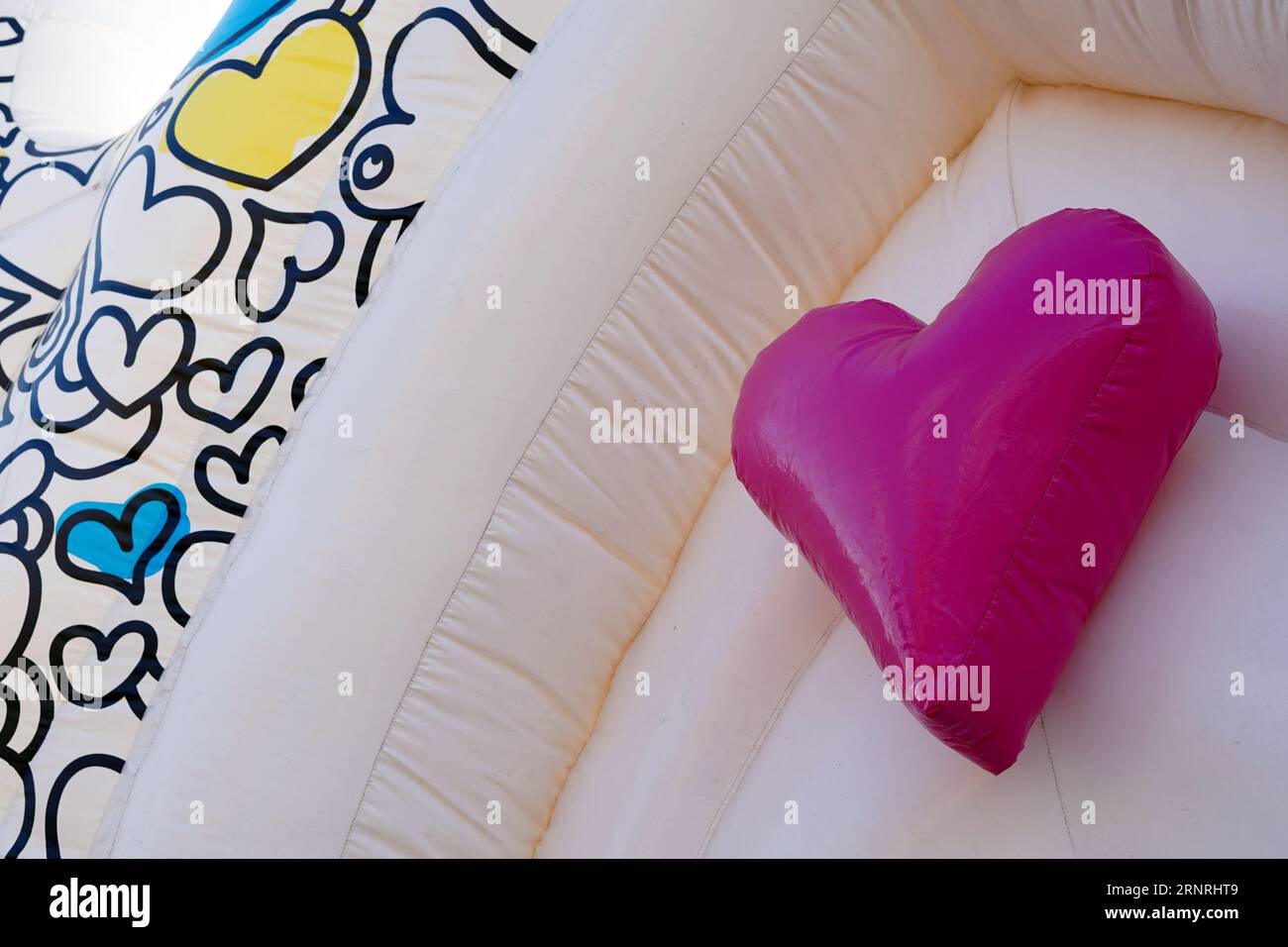 a pink inflatable heart on the side of a white inflatable chapel Stock ...
