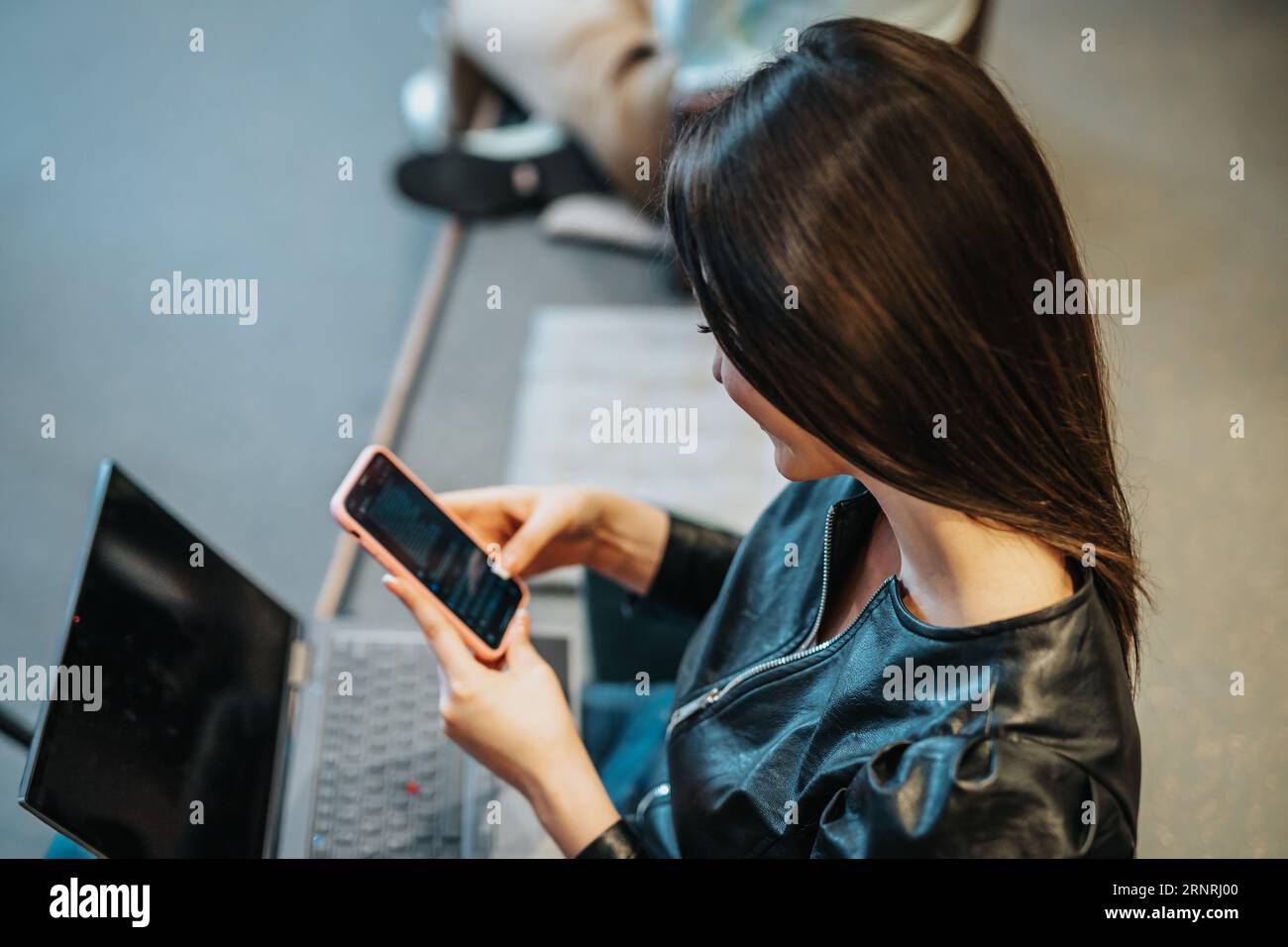 Top view of brunette female employee chatting on phone while working on ...