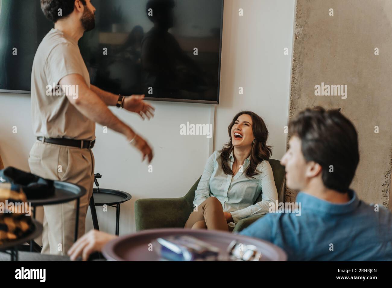 Gorgeous businesswoman laughing while her male coworker is telling a ...
