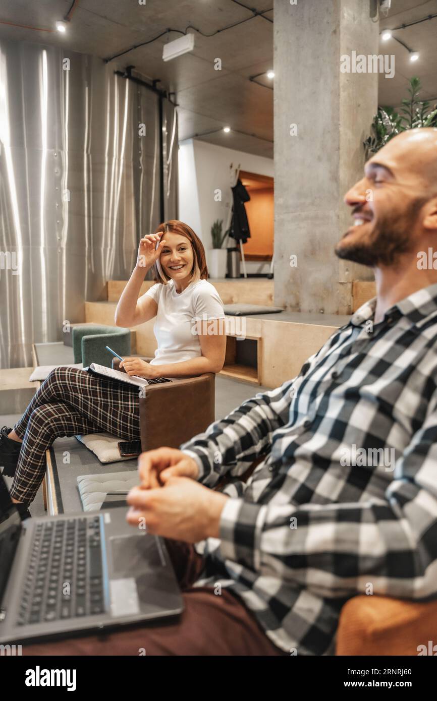 Side view photo of male and female coworkers having fun conversation ...