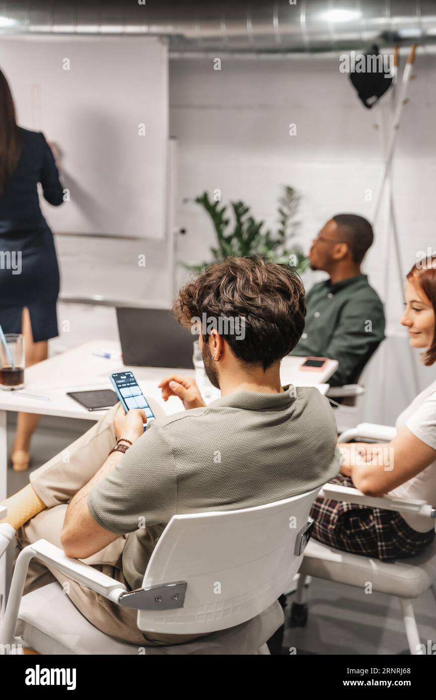 Back view photo of male person checking his phone while taking a break ...