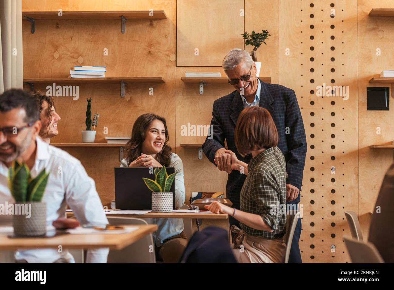 Formal senior man introducing himself to the girls at the cafe Stock ...