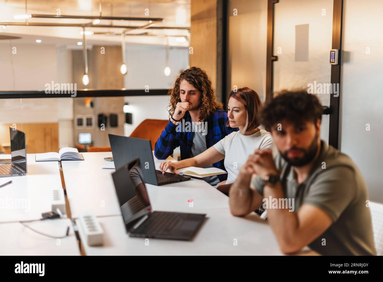 Young, skilled programmers, executing and testing code, reading ...
