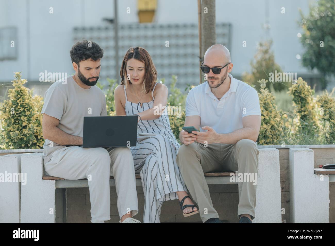 A team of architects and engineers discussing a blueprint outdoors ...
