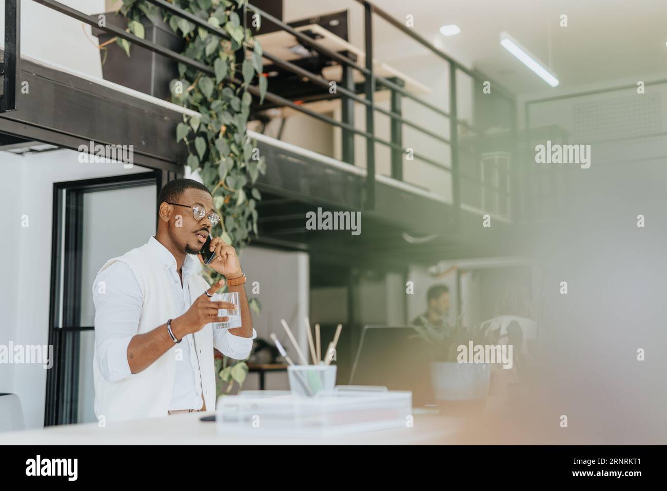 Concentrated businessman consulting client by phone at workplace ...