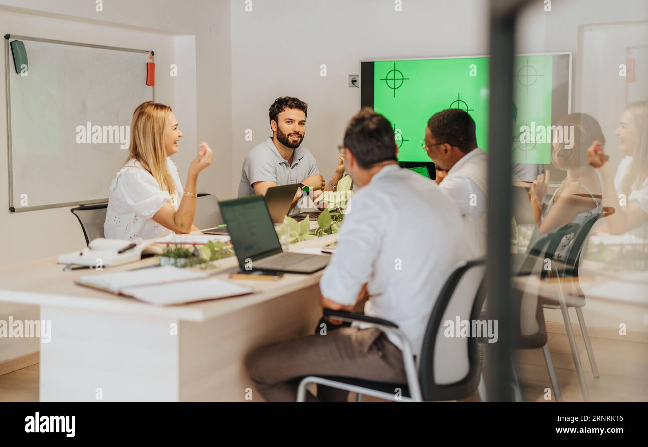 A diverse group of professionals collaborate in a modern meeting room ...