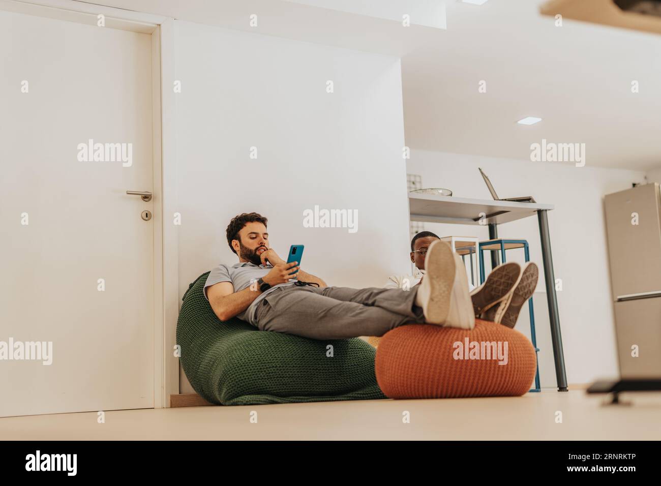 Diverse colleagues taking a break from work, lying on lazy bags ...