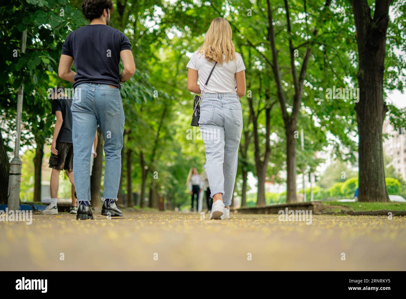 Low angle view photo of college couple going home together after ...