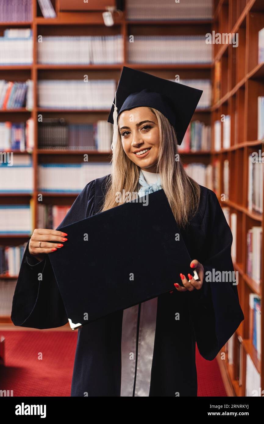 Young and pretty girl holding her bachelor's degree while wearing her ...