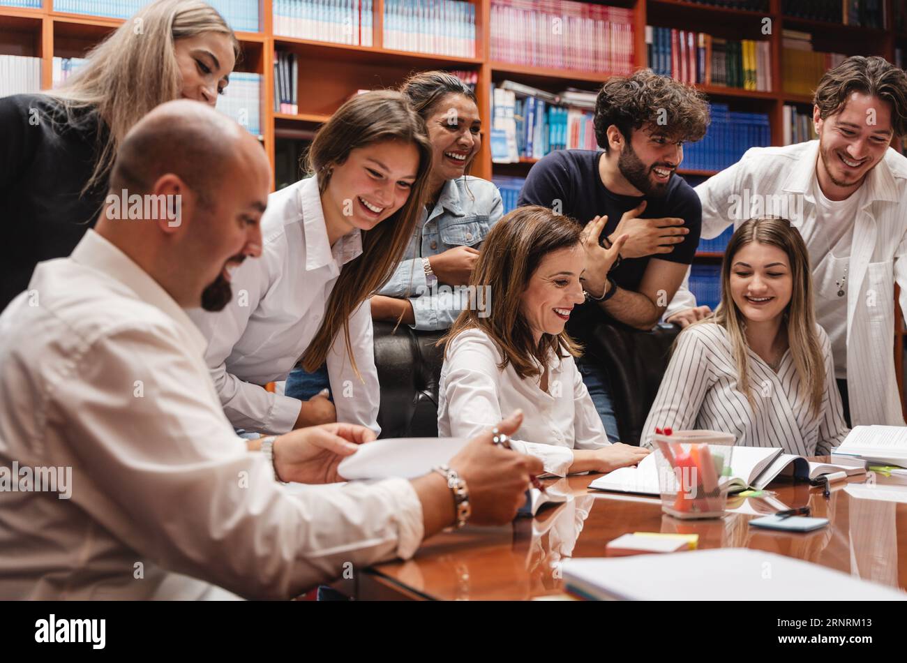 Two professors and their students laughing and having fun in a library ...