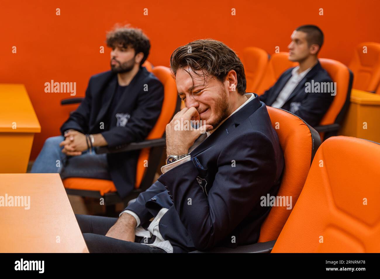 Very emotional student sitting in a lecture hall and crying with his ...