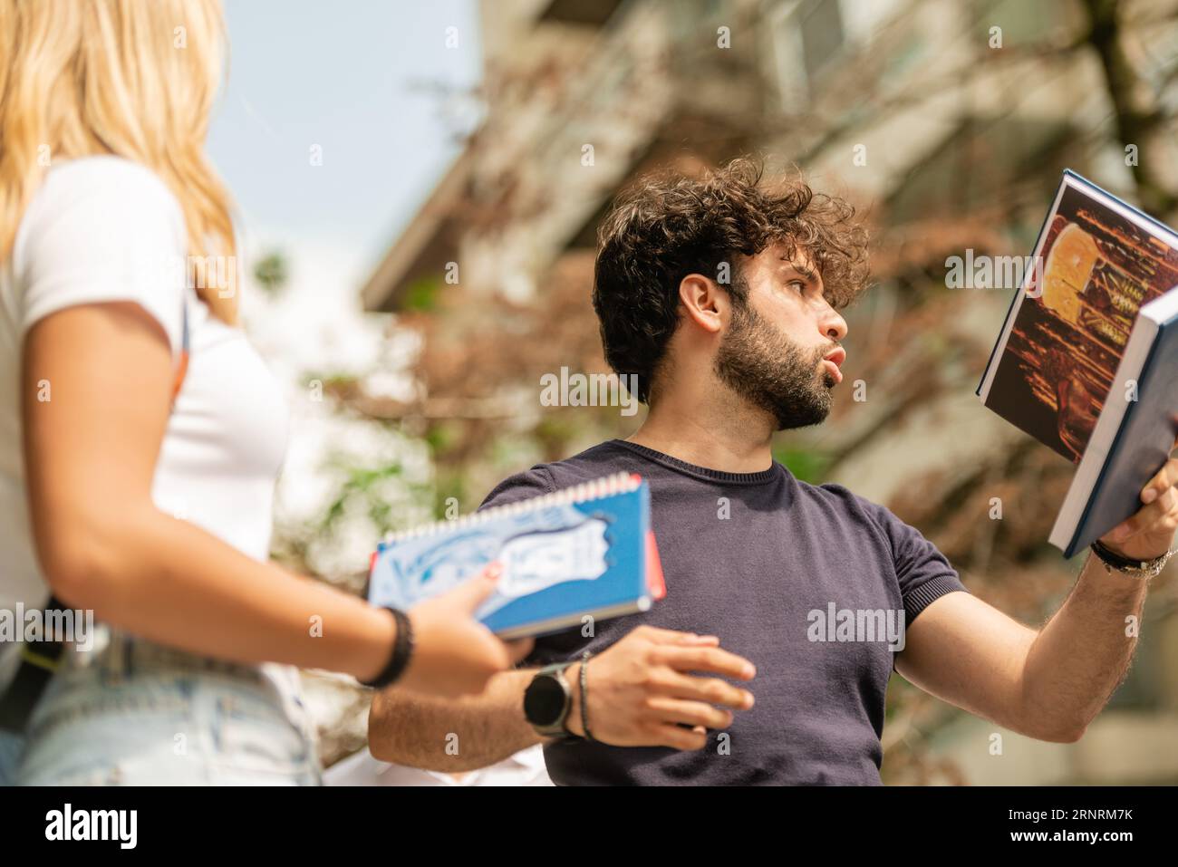Two casually dressed students standing outside and holding their ...