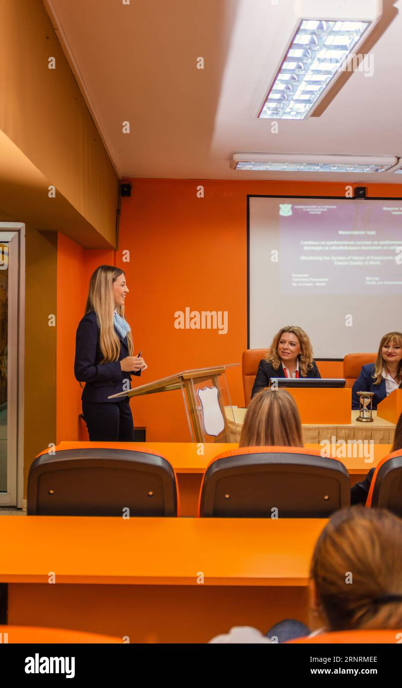 Young university student giving a speech on the podium defending her ...