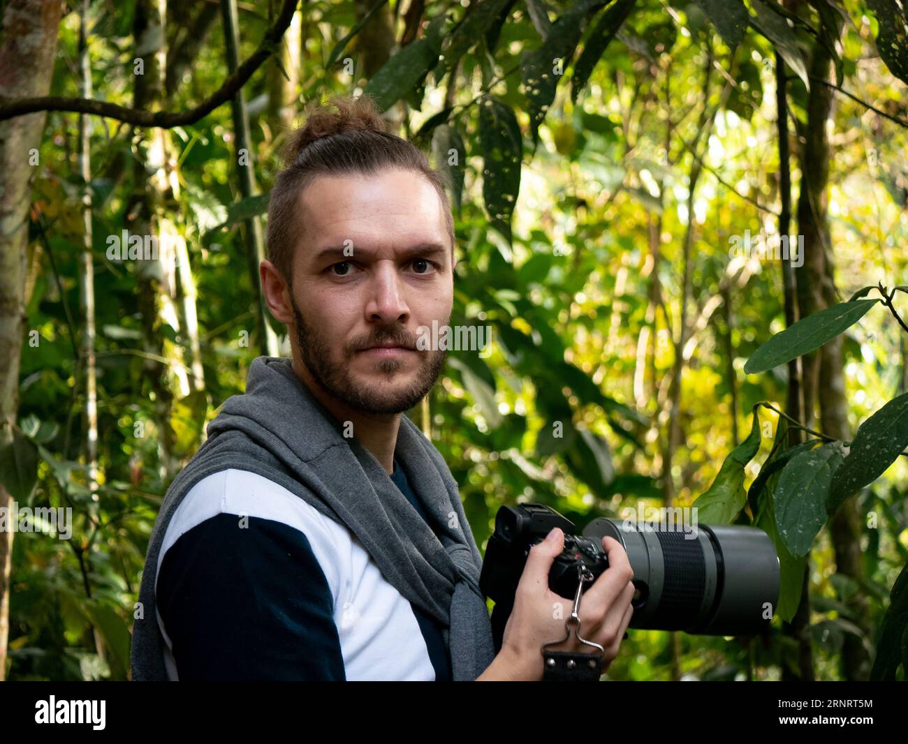 A Young White Photographer Holds his Camera with a Large Lens in the ...