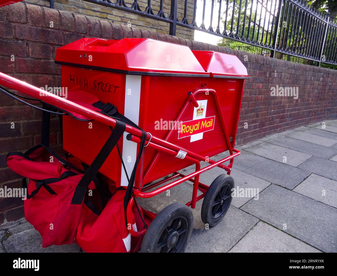 Red United Kingdom Royal Mail trolley on pavement during a letter ...