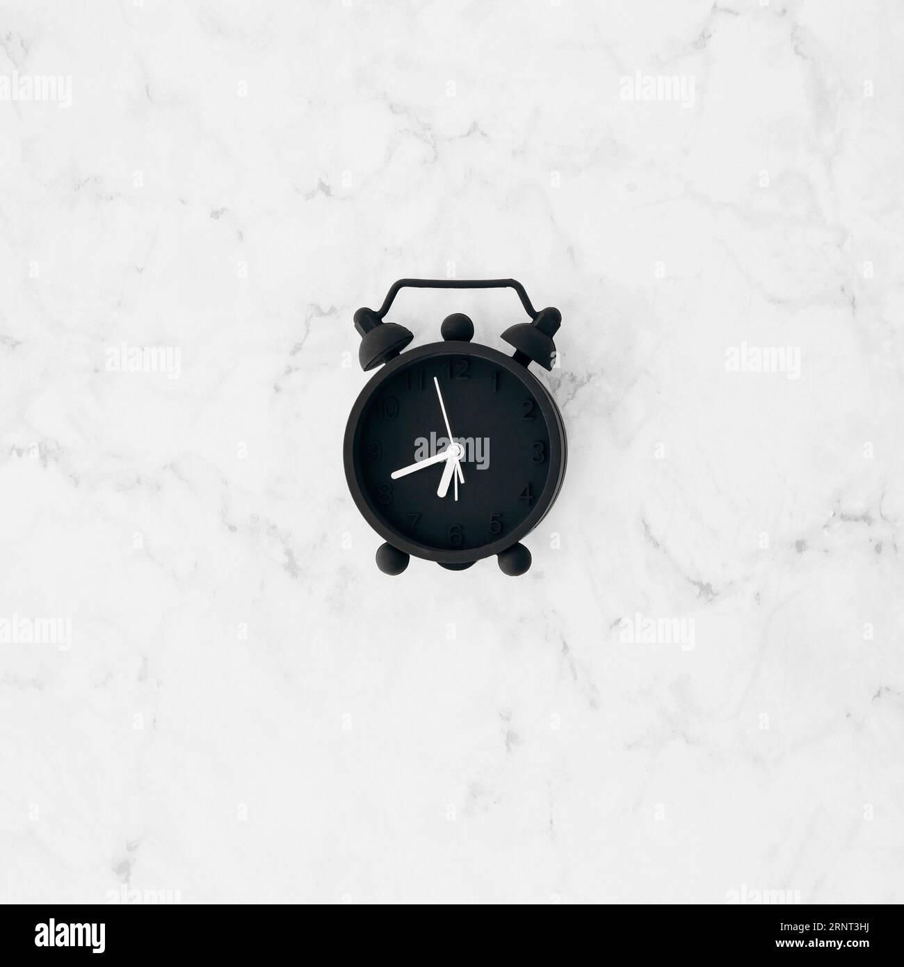 Elevated view black alarm clock white textured wallpaper Stock Photo ...