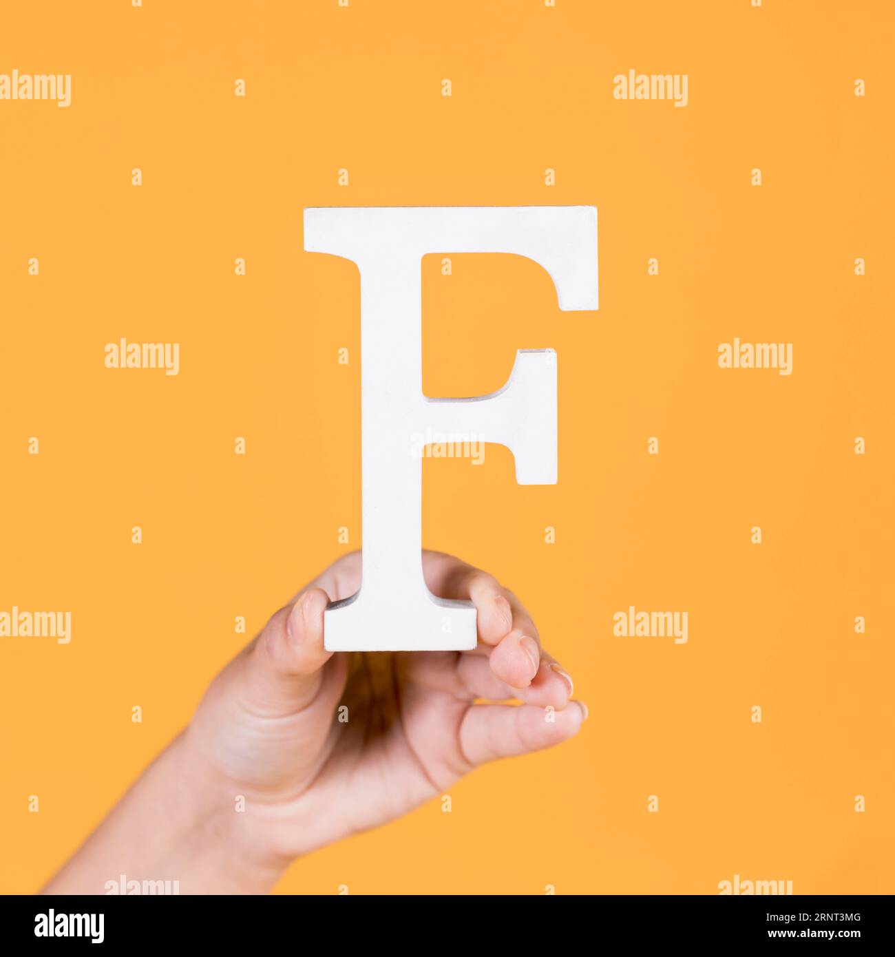Female hand holding up uppercase capital letter f Stock Photo - Alamy