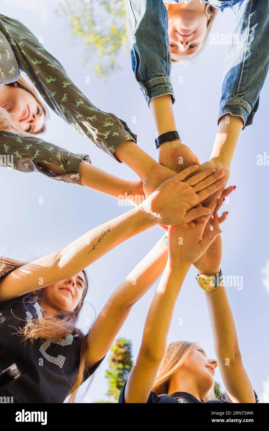 Female teen friends stacking hands together Stock Photo - Alamy