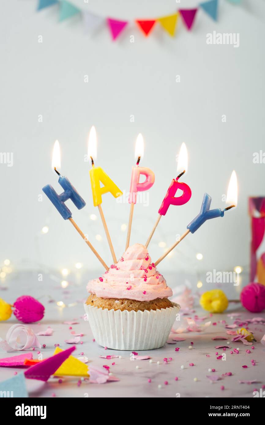 Front view birthday cupcake with lit candles Stock Photo - Alamy