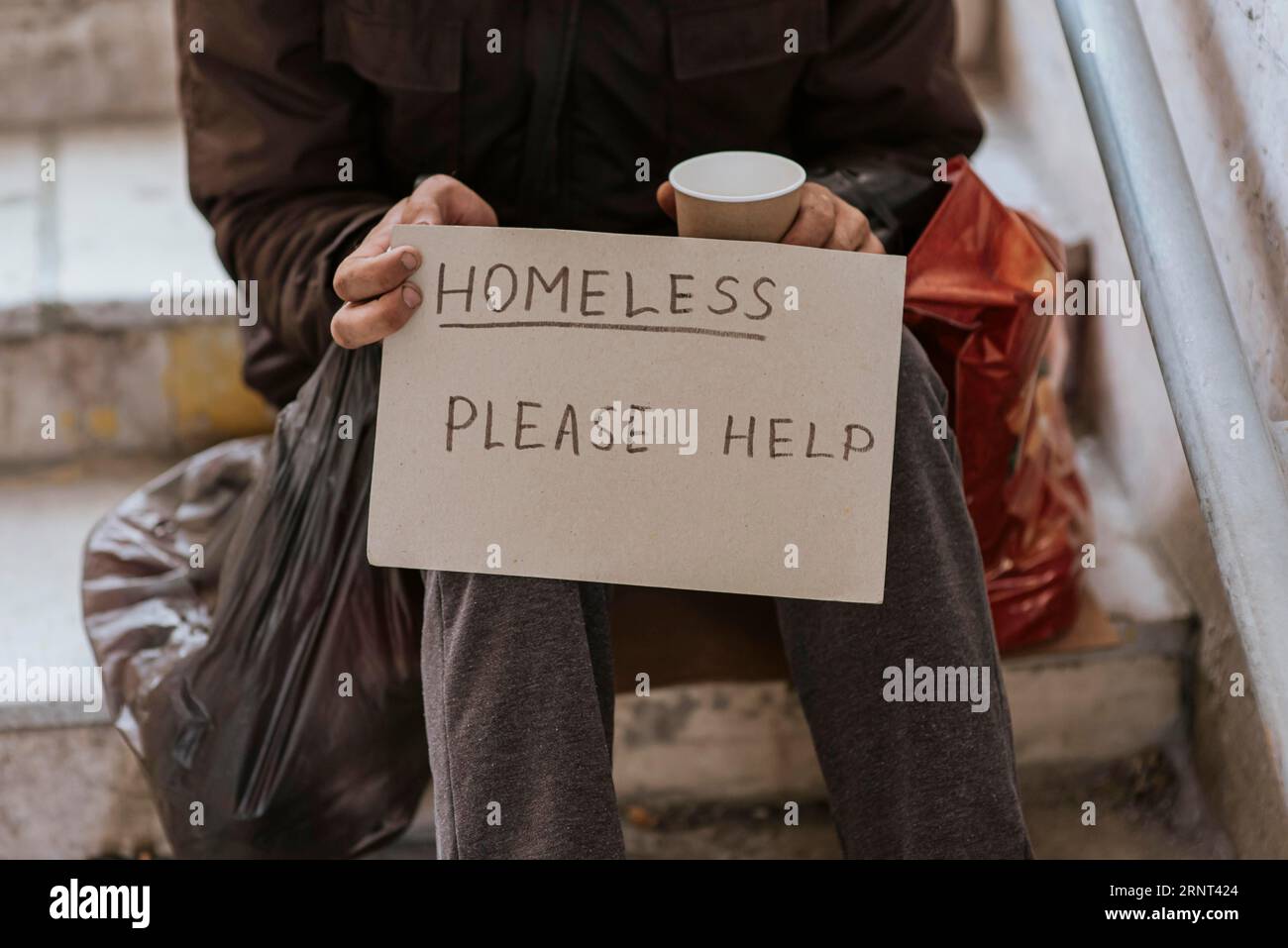 Front view homeless man holding help sign plastic bag Stock Photo - Alamy