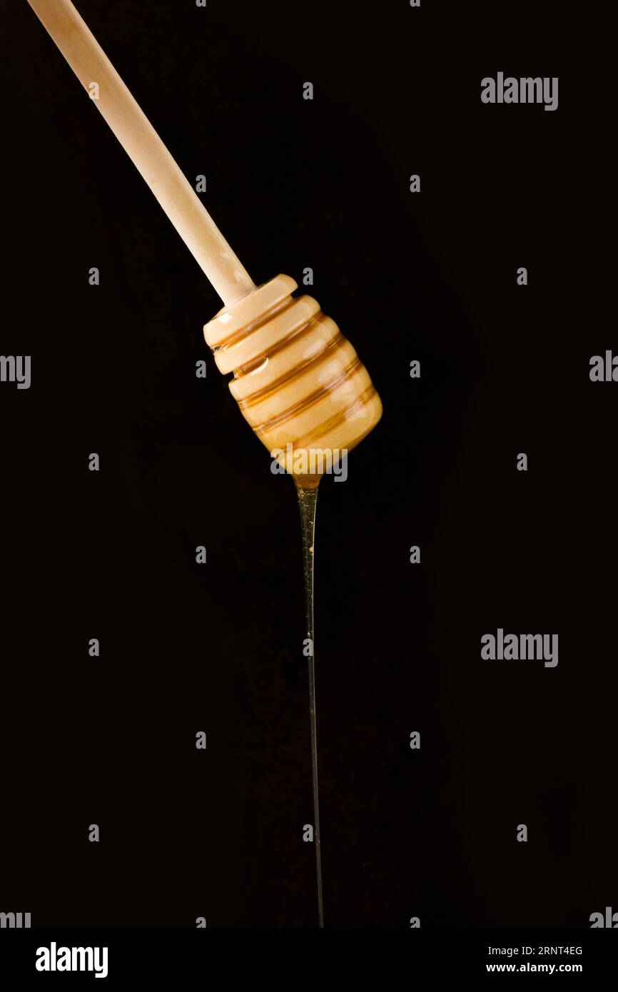 Honey falling from spoon Stock Photo - Alamy