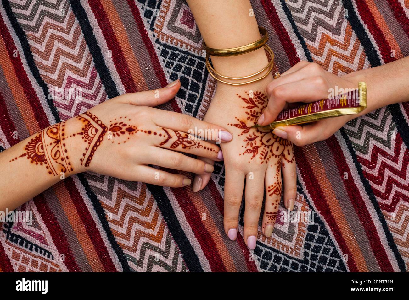 Artist making mehndi womans hand bright table Stock Photo - Alamy