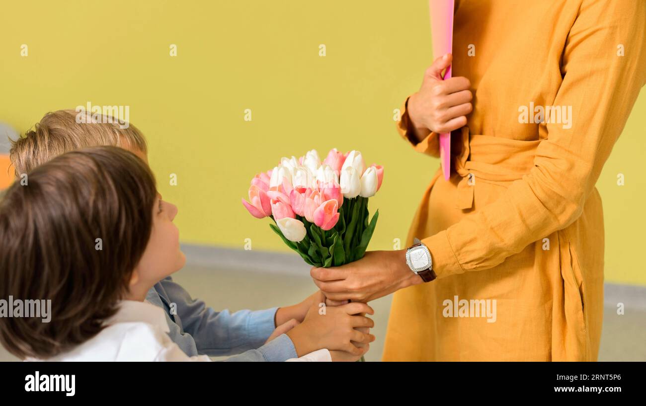 Children giving their teacher bouquet flowers Stock Photo - Alamy