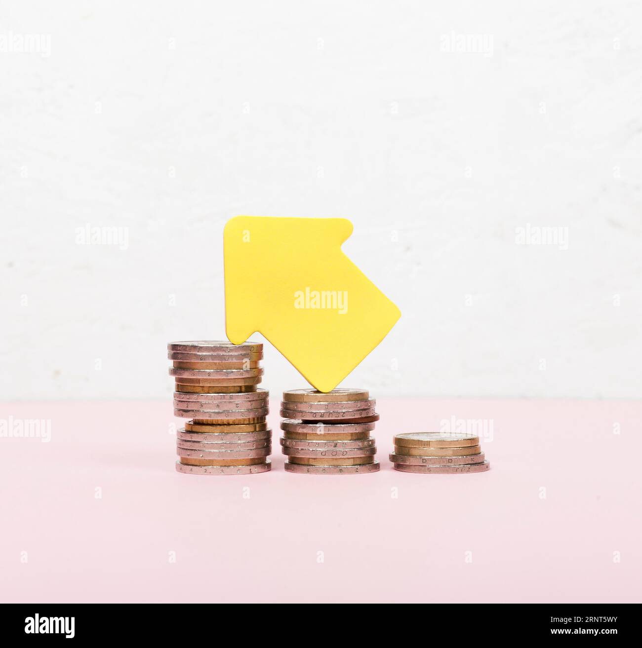 Pile coins arrow pointing up Stock Photo - Alamy